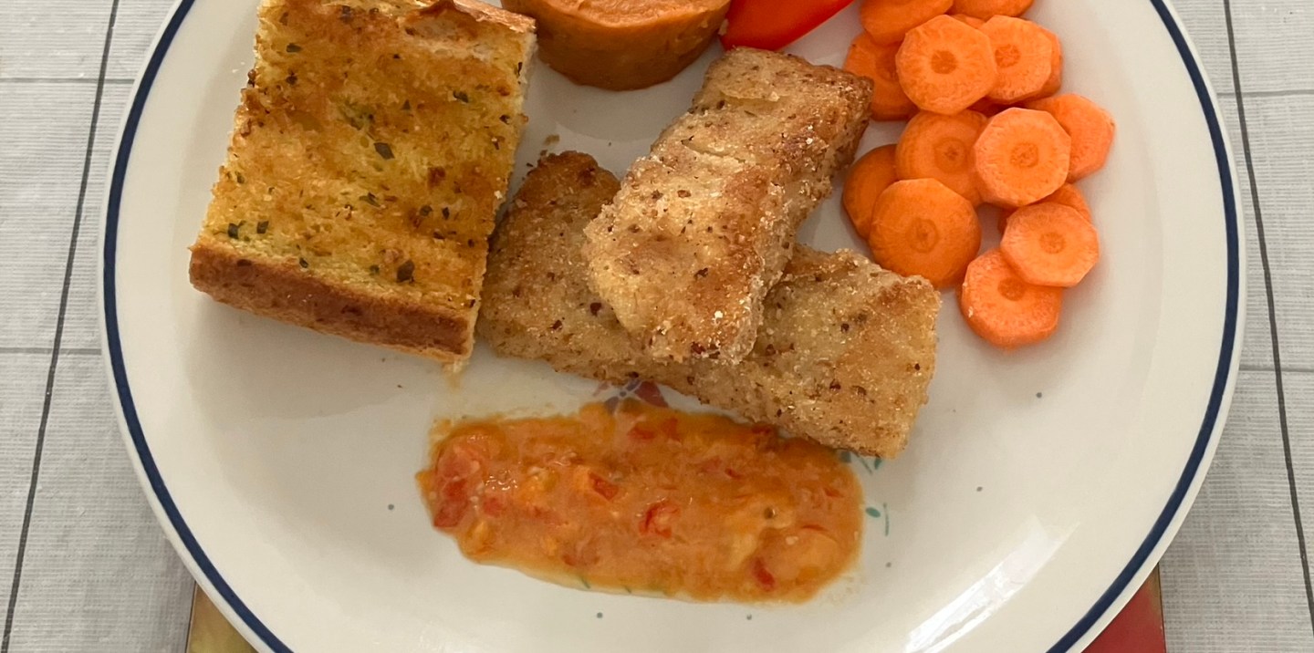 Pan cooked fish carrot sweet potato and garlic bread with tomato puree ...