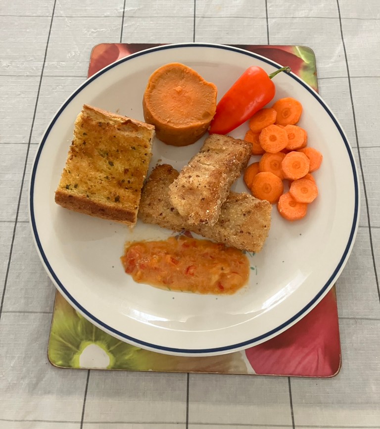 Pan cooked fish carrot sweet potato and garlic bread with tomato puree ...